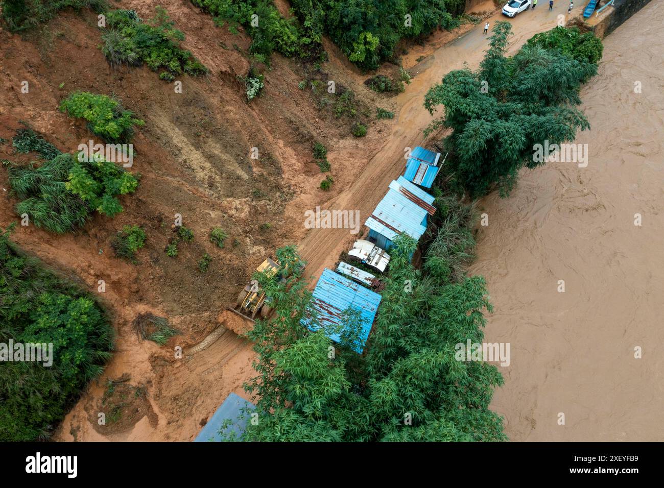 CONGJIANG, CHINA - JUNE 30, 2024 - Workers drive machinery to clear a ...