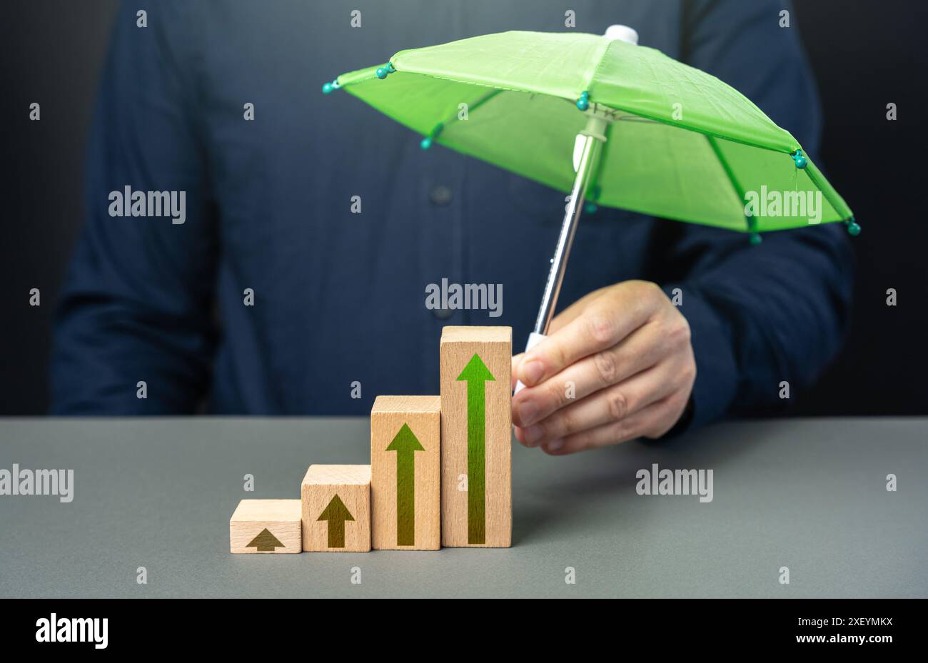 Businessman holding protection umbrella over growth graph. Career ...