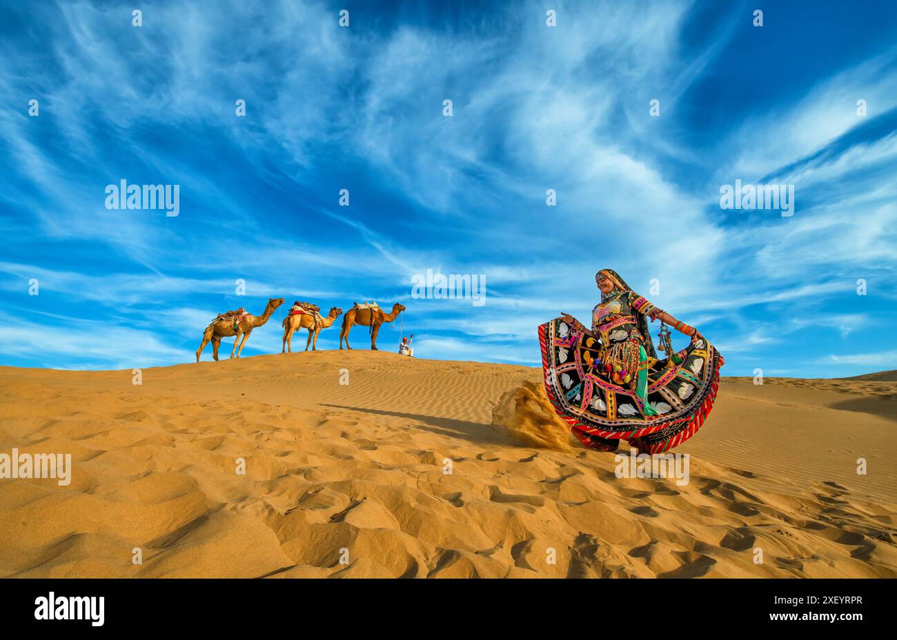 A vibrant Rajasthani dancer twirls on the sand dunes of Jaisalmer, with ...