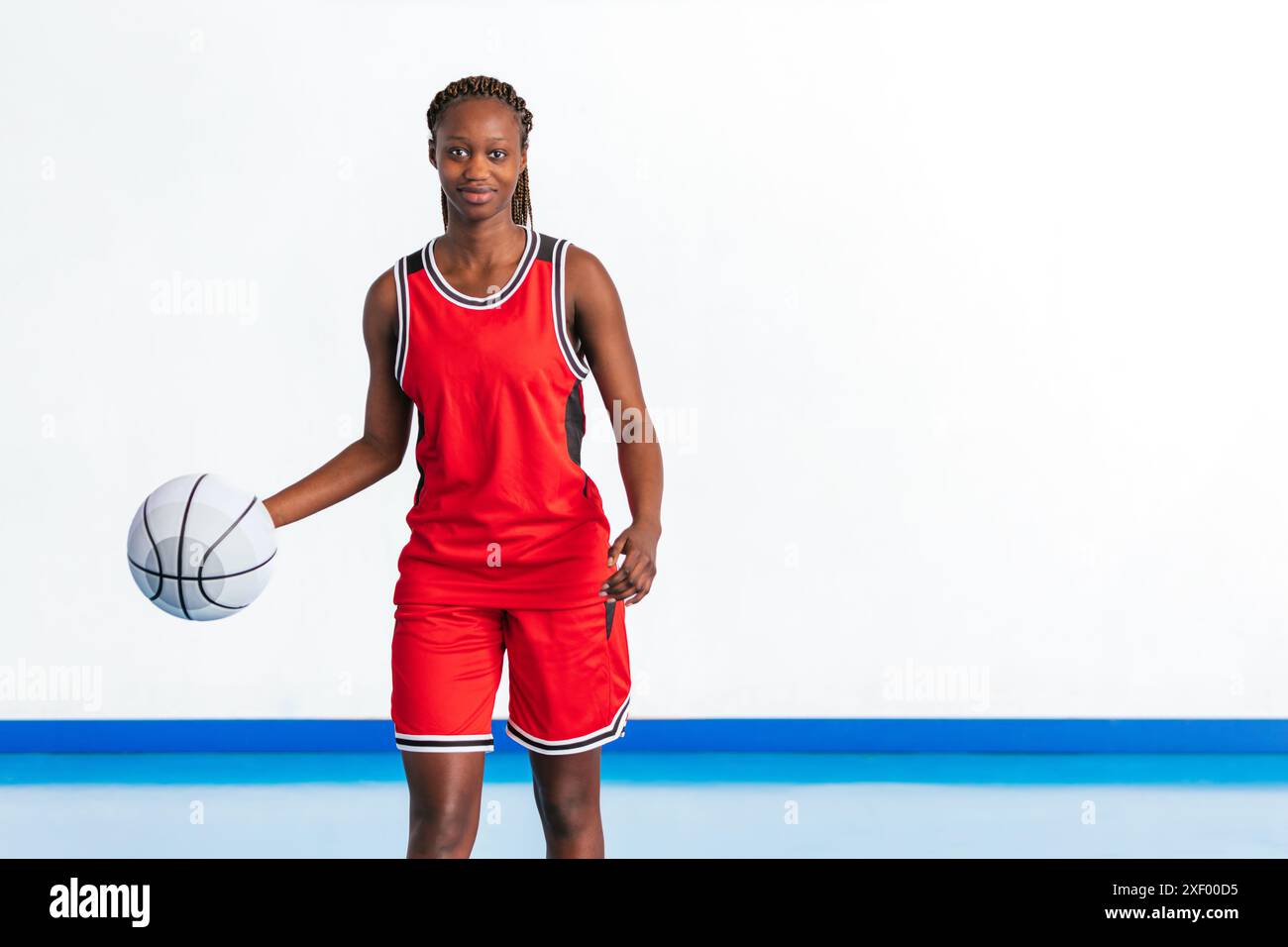 Horizontal photo a young female basketball player in a red uniform ...