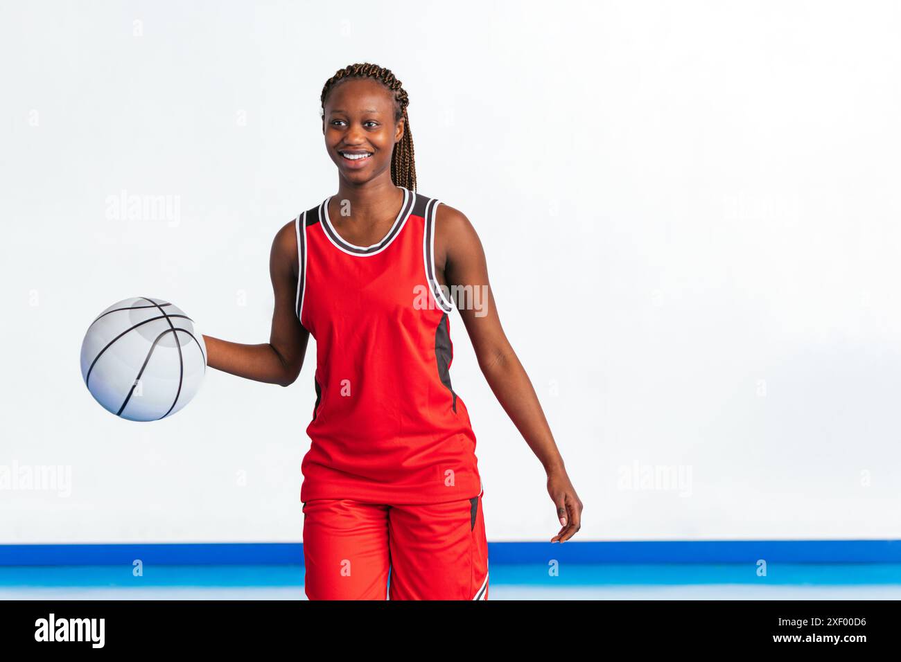 Horizontal photo a young female basketball player in a red uniform ...