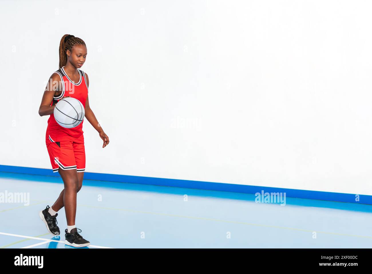 Horizontal photo a young female basketball player in a red uniform ...
