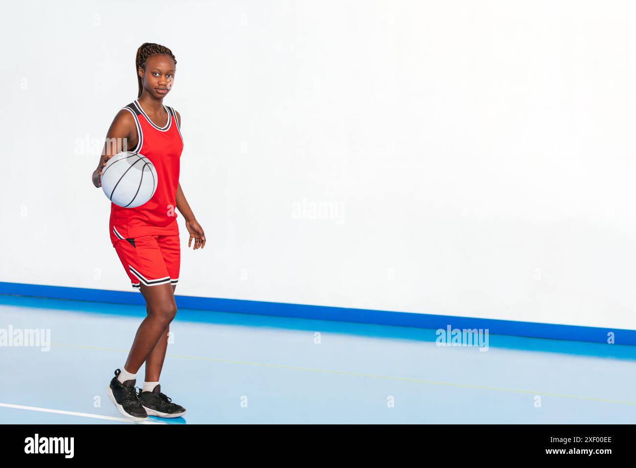 Horizontal photo a young female basketball player in a red uniform ...