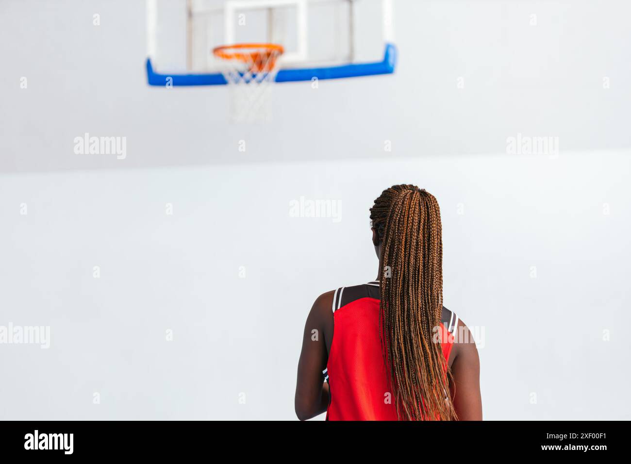 Horizontal photo a female basketball player in a red uniform focuses on ...