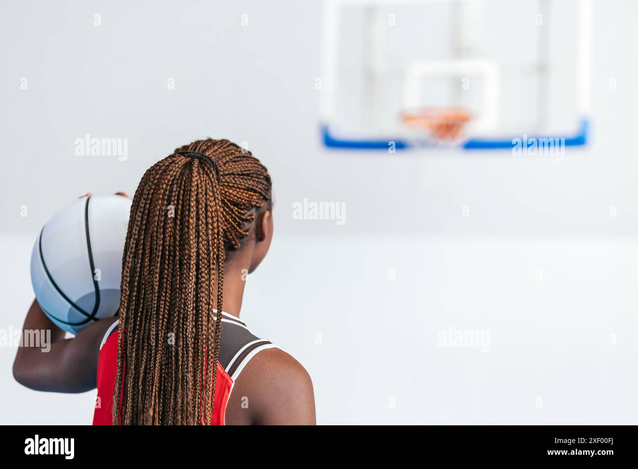 Horizontal photo a female basketball player in a red uniform stands on ...