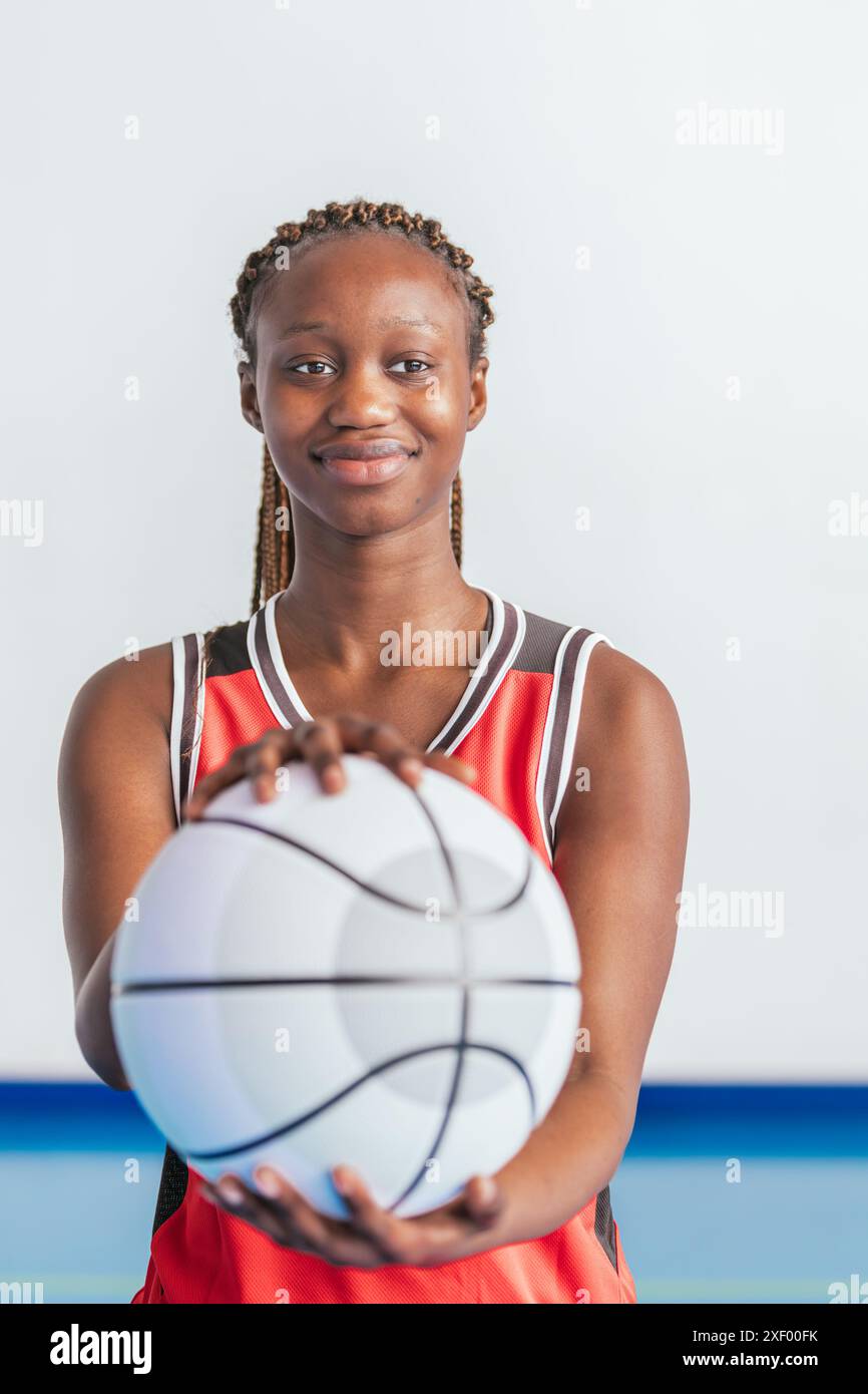 Vertical photo a confident female basketball player in a red uniform ...
