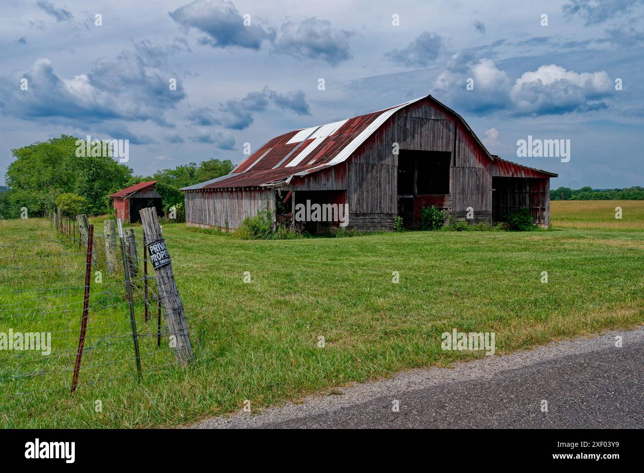 Rustic barn along the road with red faded paint and a rusty metal roof ...