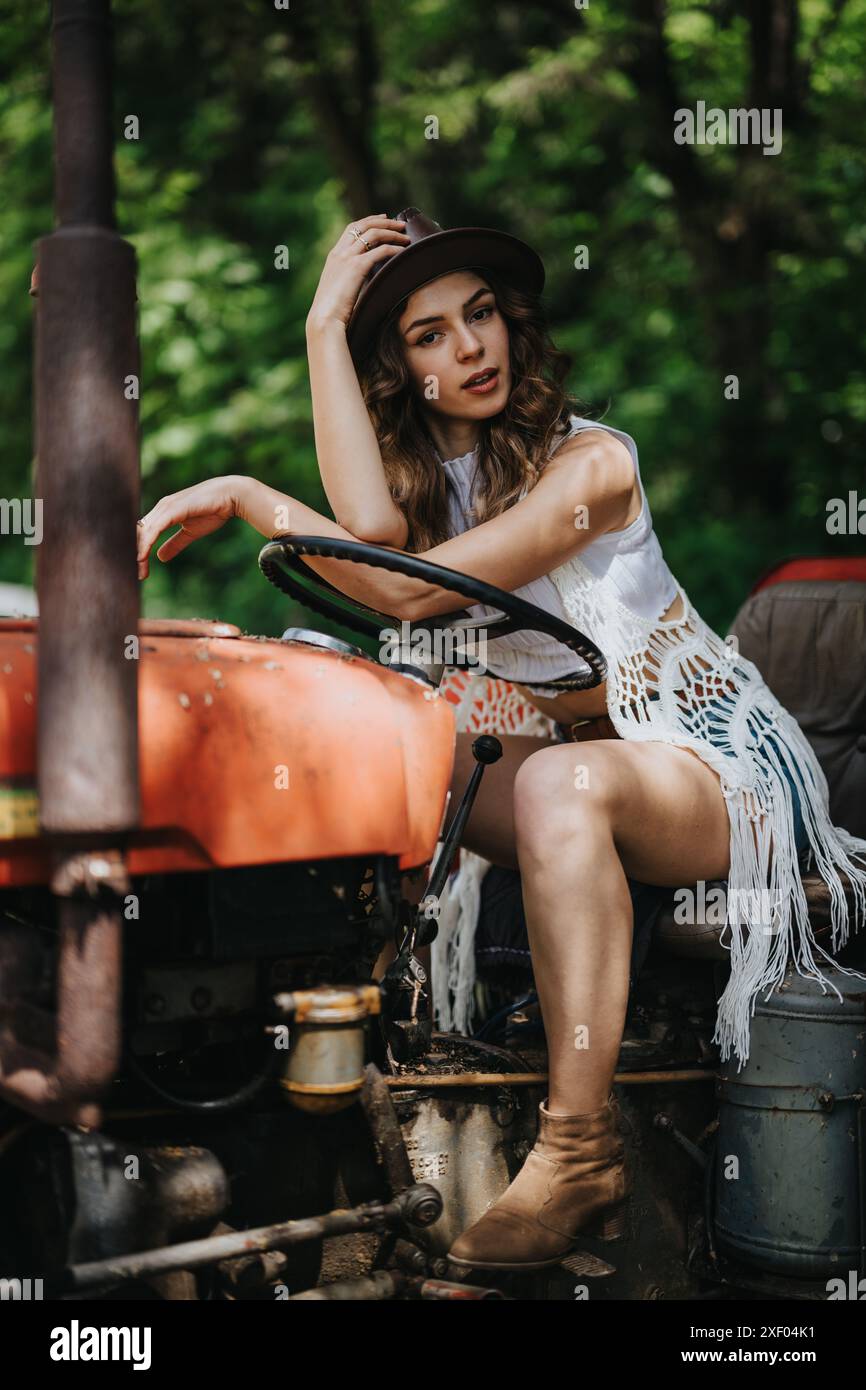 Young woman in country style clothing posing on tractor outdoors Stock ...