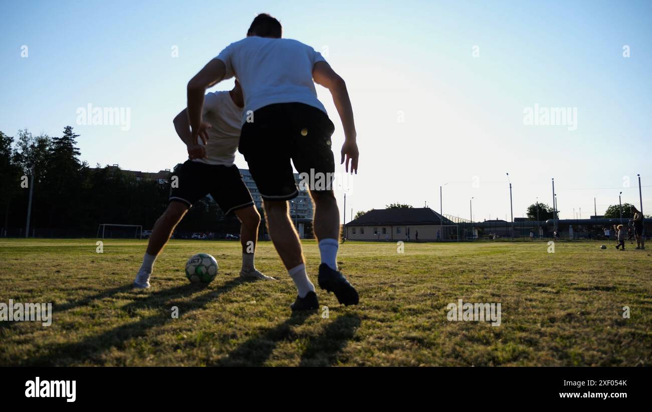 Two sportsmen playing in soccer in stadium at sunset. Professional ...