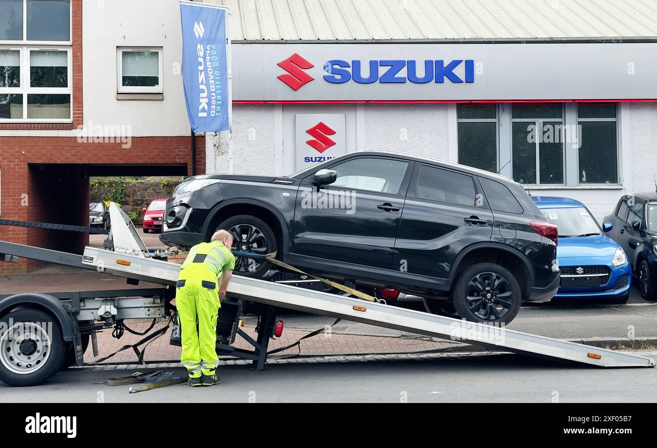 Car being offloaded from recovery vehicle at garage Stock Photo - Alamy