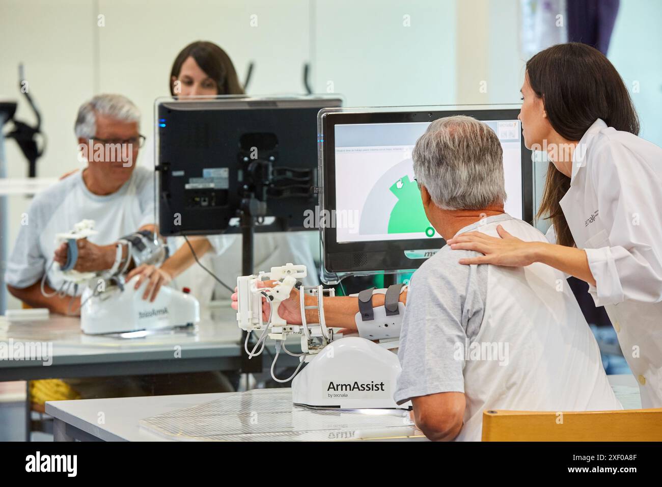 Therapist and patient with assistive robot for upper limb ...