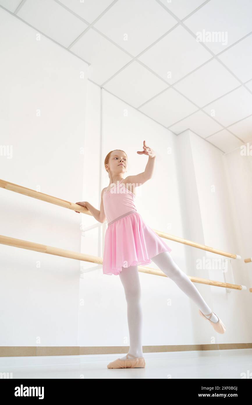 Young ballet girl at studio lesson. Training performance. Stretching ...
