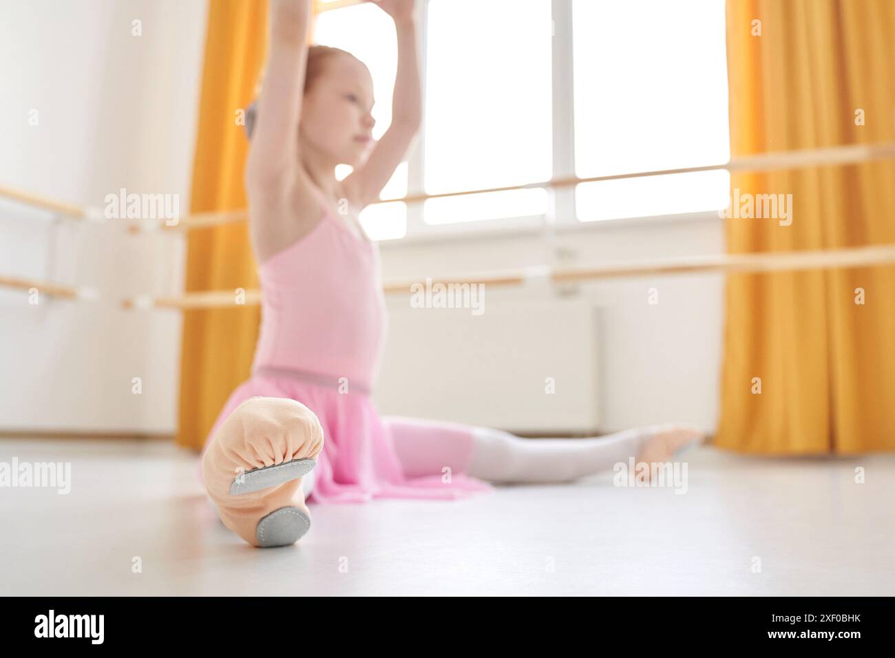 Young ballet girl at studio lesson. Training performance. Stretching ...