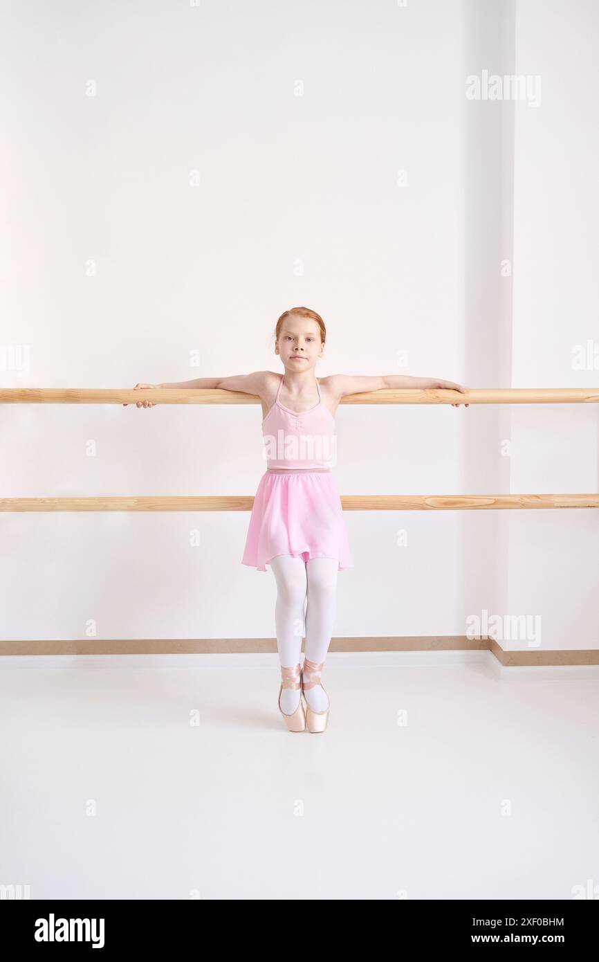 Young ballet girl at studio lesson. Training performance. Stretching ...