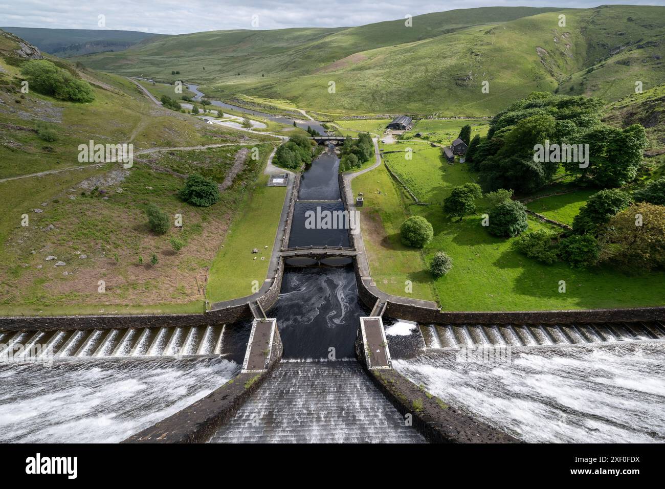 Claerwen Dam in the Elan Valley, with water flowing over the top. The ...