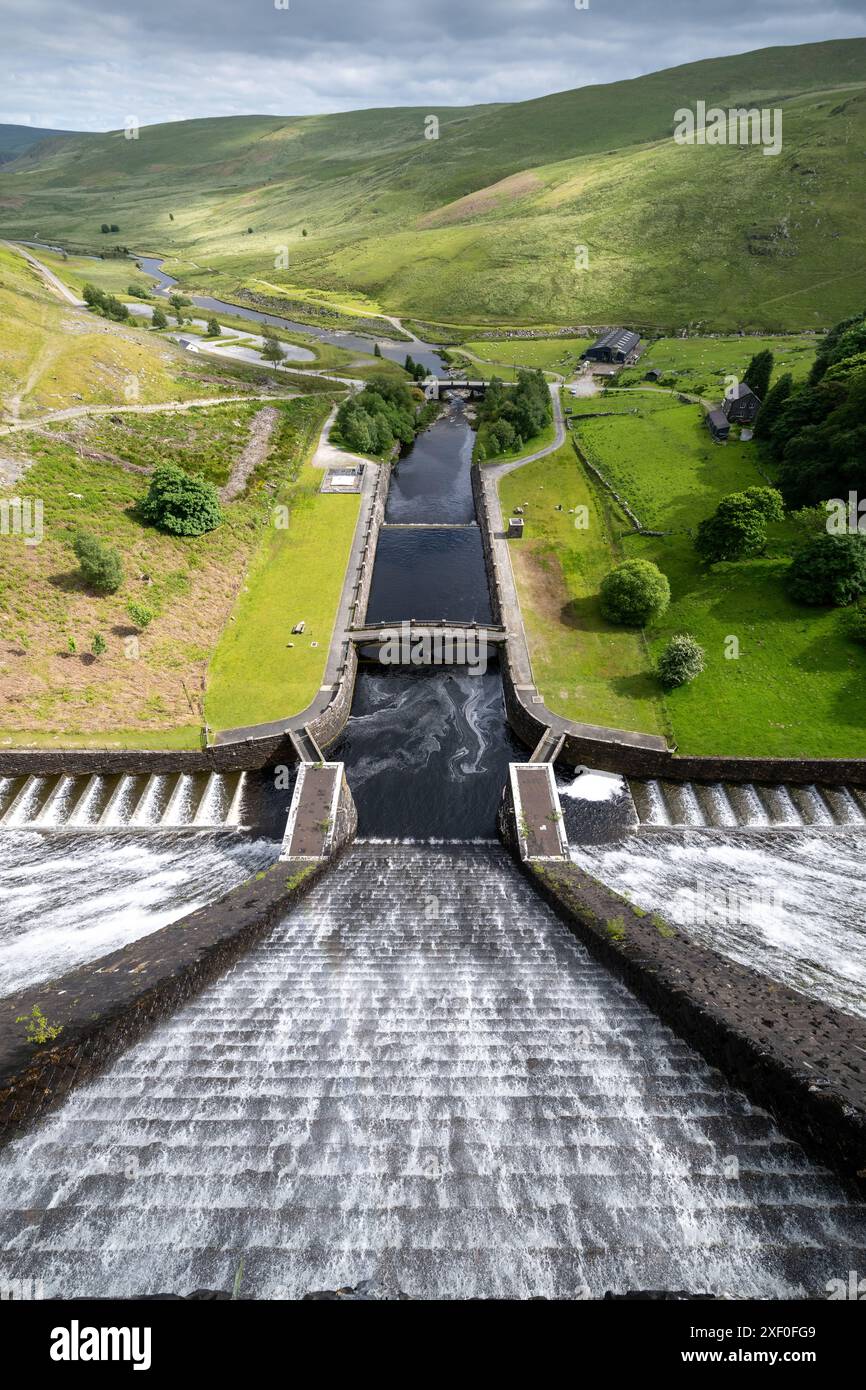 Claerwen Dam in the Elan Valley, with water flowing over the top. The ...