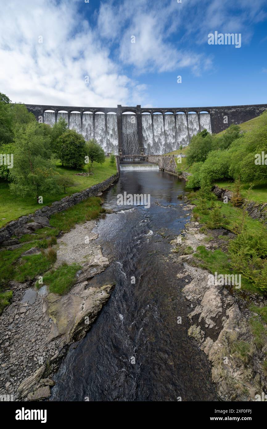 Claerwen Dam in the Elan Valley, with water flowing over the top. The ...