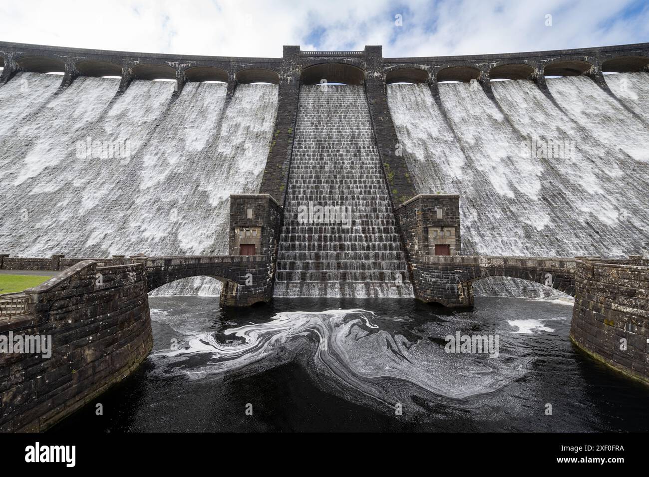Claerwen Dam in the Elan Valley, with water flowing over the top. The ...