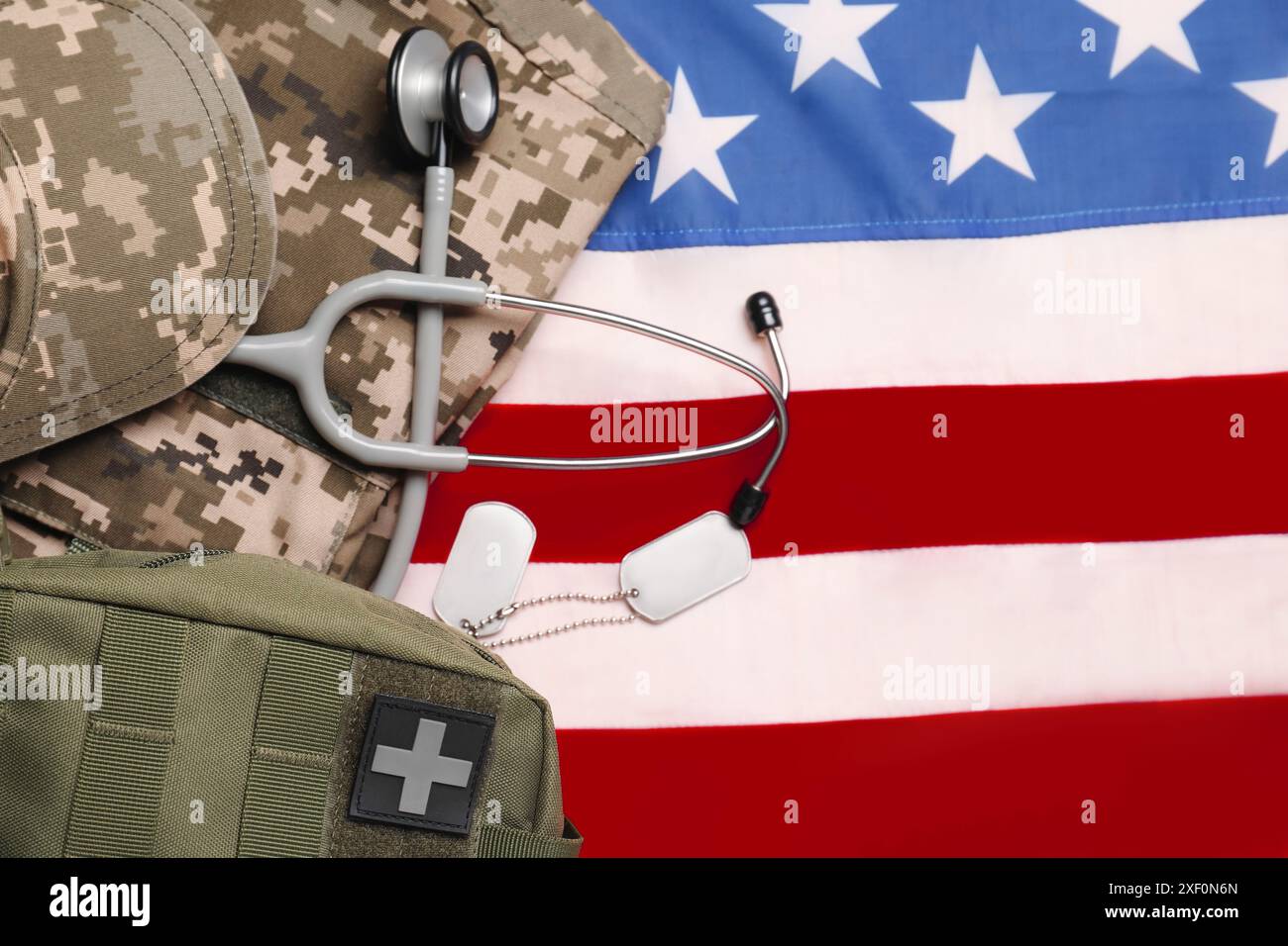 Stethoscope, first aid kit, tags and military uniform on USA flag, top ...