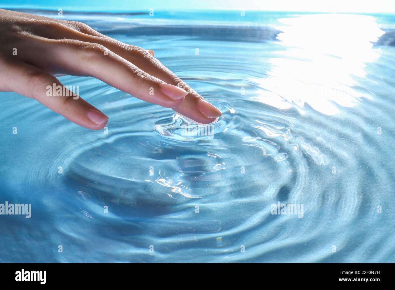 Woman touching clear water, closeup. Making ripples Stock Photo - Alamy