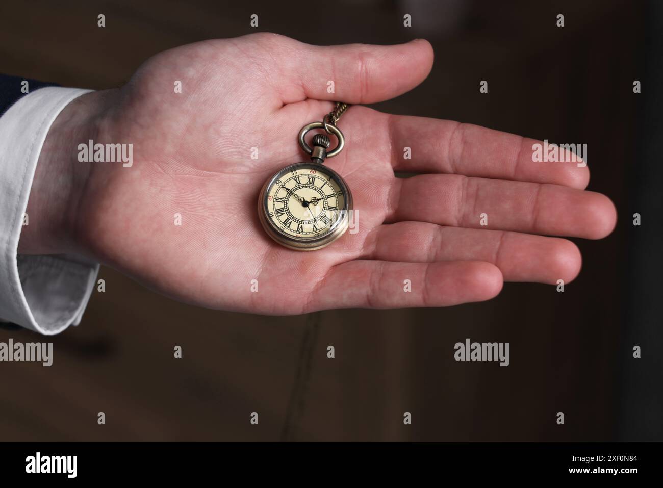 Hand holding watch on chain hi-res stock photography and images - Alamy