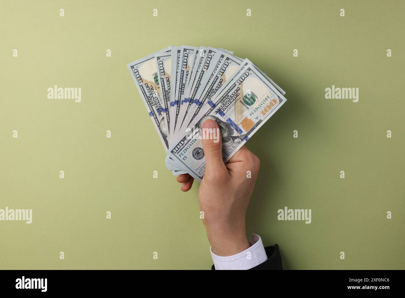 Money exchange. Man holding dollar banknotes on olive background, top ...