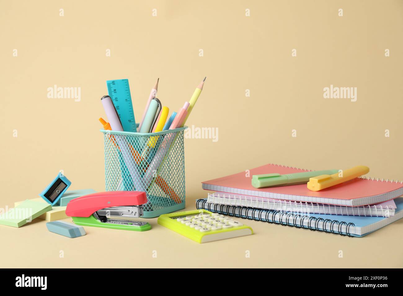 Bright stapler and other stationery on beige background, space for text ...