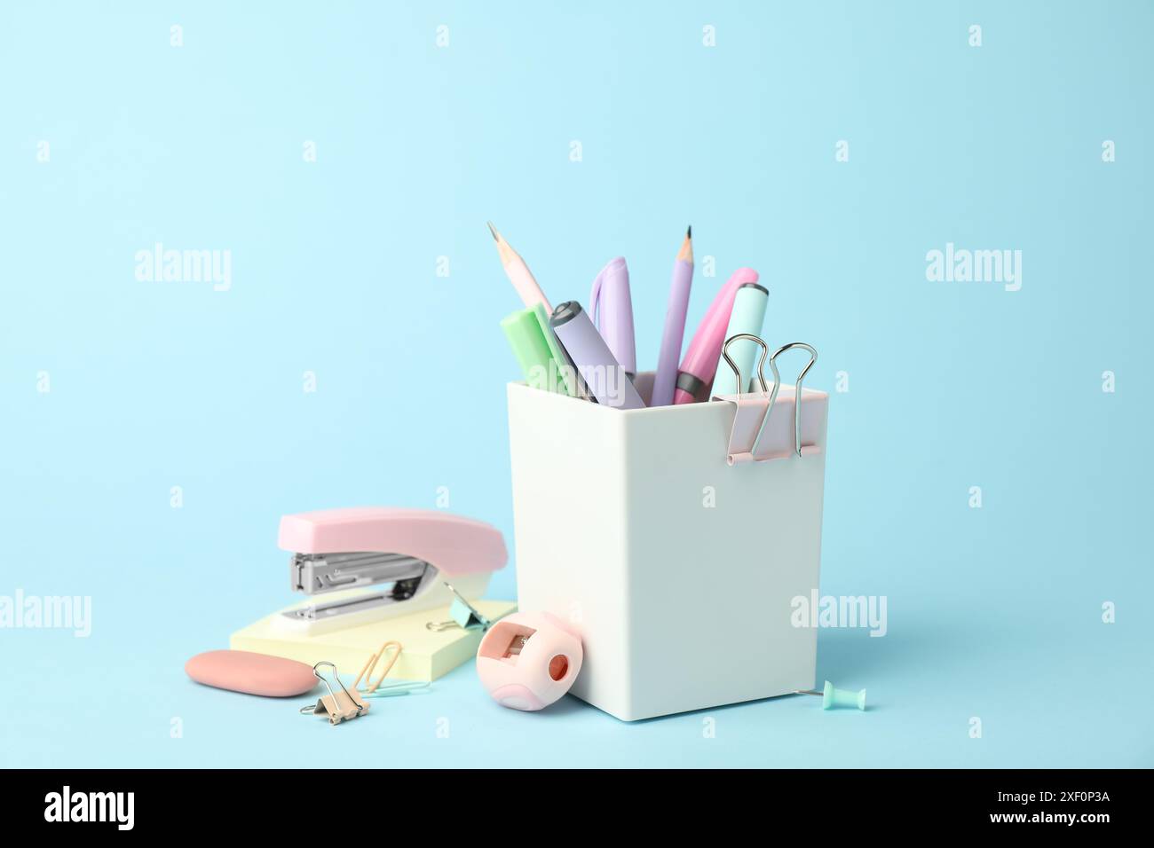 Stapler and other stationery on light blue background Stock Photo - Alamy
