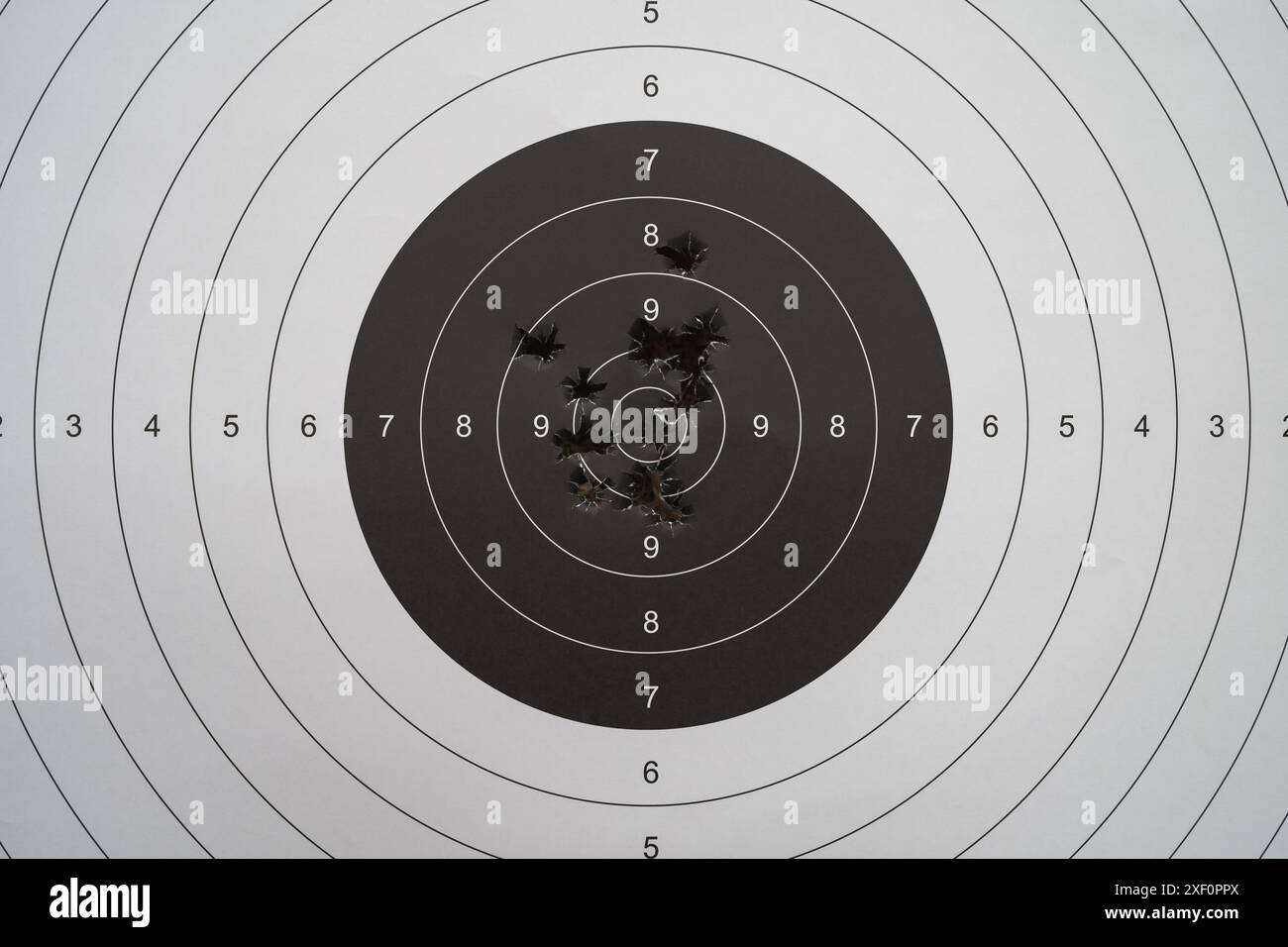 A shooting paper target with bullet holes in the center. Close up Stock ...