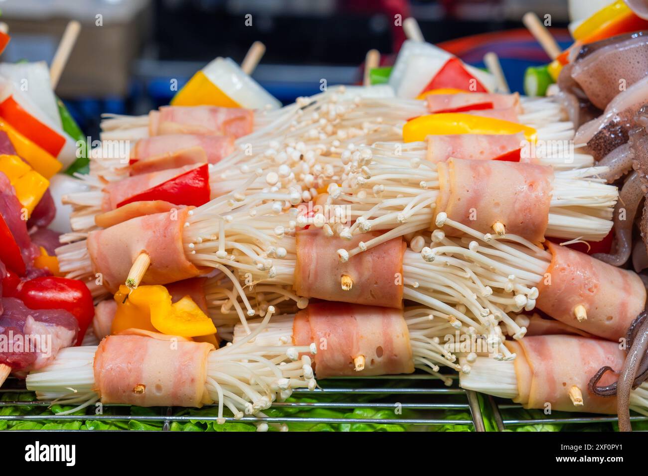 Bacon wrapped enoki mushrooms skewers. Thai strret food on night market ...