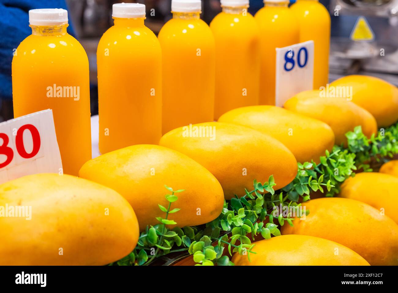 Fresh mango juice in bottles and fresh fruits displayed at street food ...