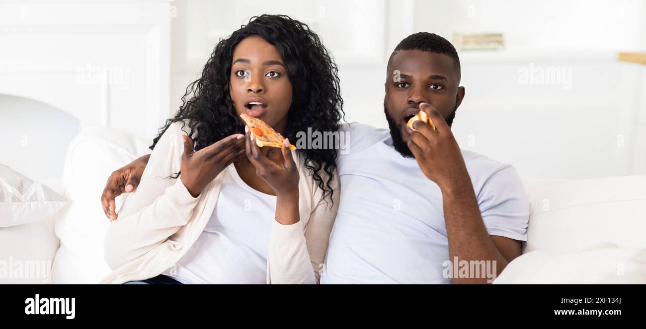 Couple Eating Pizza While Relaxing on Couch Stock Photo - Alamy