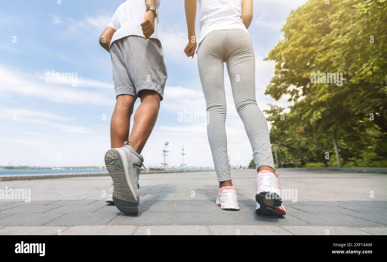 Unrecognizable Black Couple Jogging Along River Bank, Low-Angle, Rear ...
