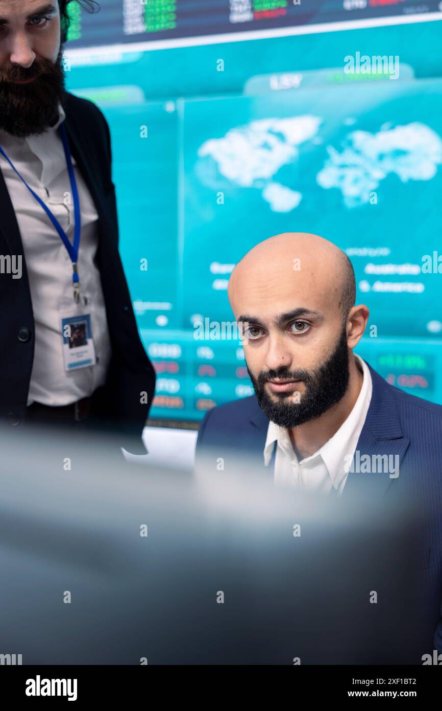 Financial analyst works on resource allocation plans with his staff, analyzing reports and sales ...