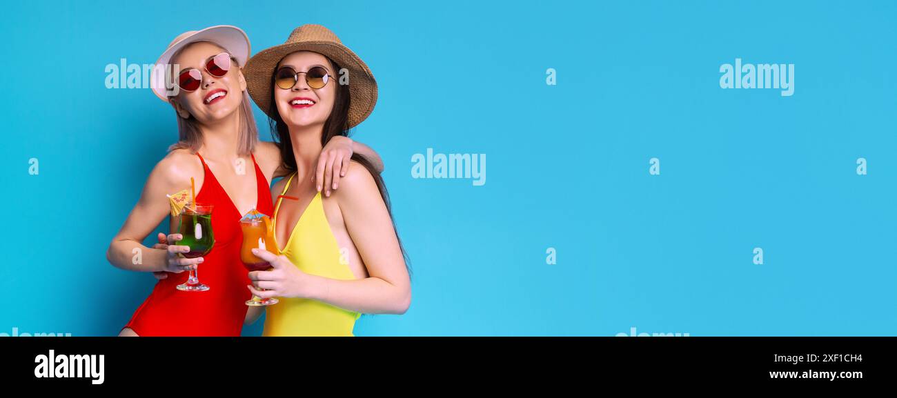 Two Women In Swimsuits Smile With Cocktails On Blue Stock Photo - Alamy