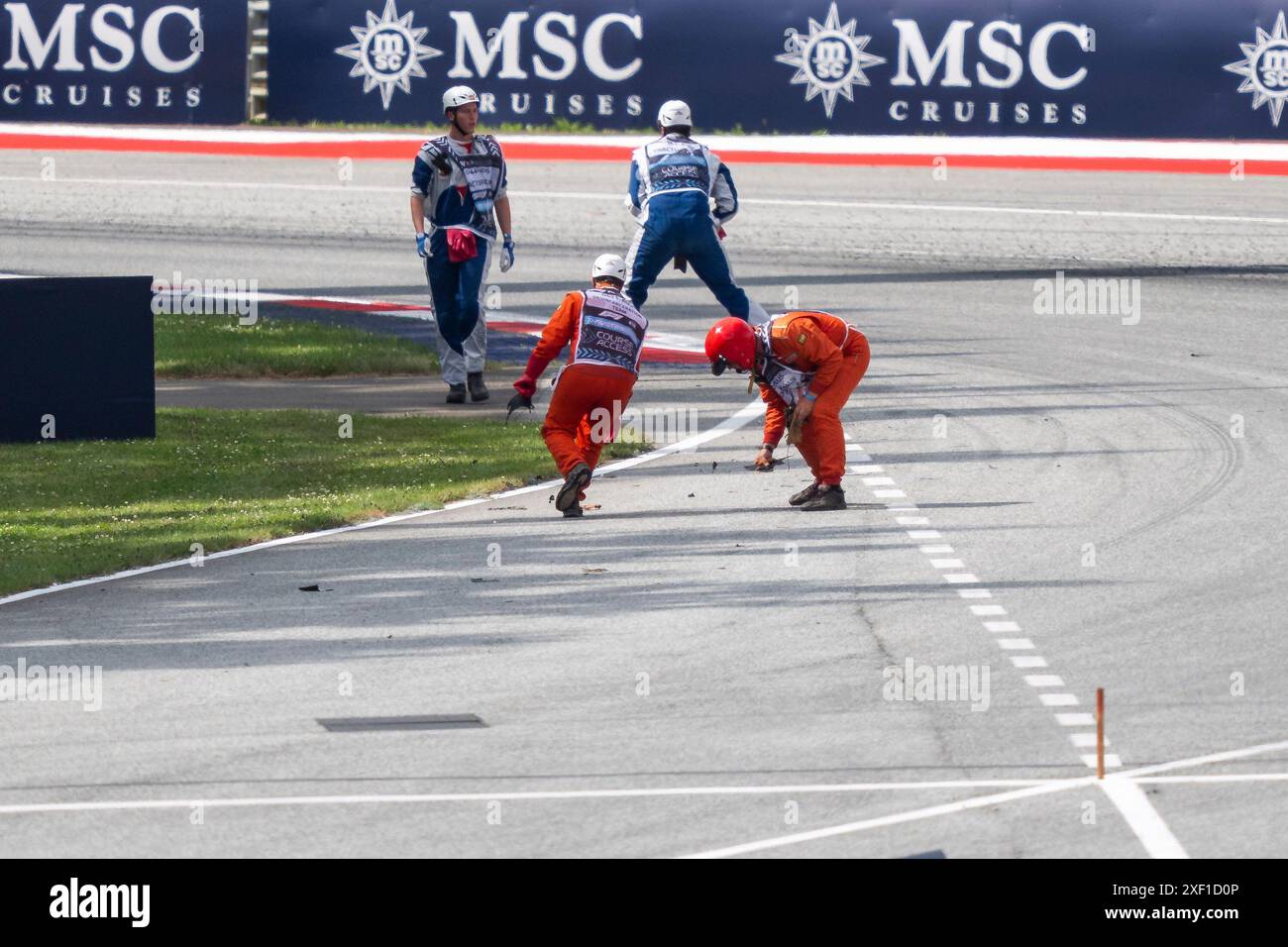 SPIELBERG, AUSTRIA - JUNE 30: Marshals clean the race track during the ...