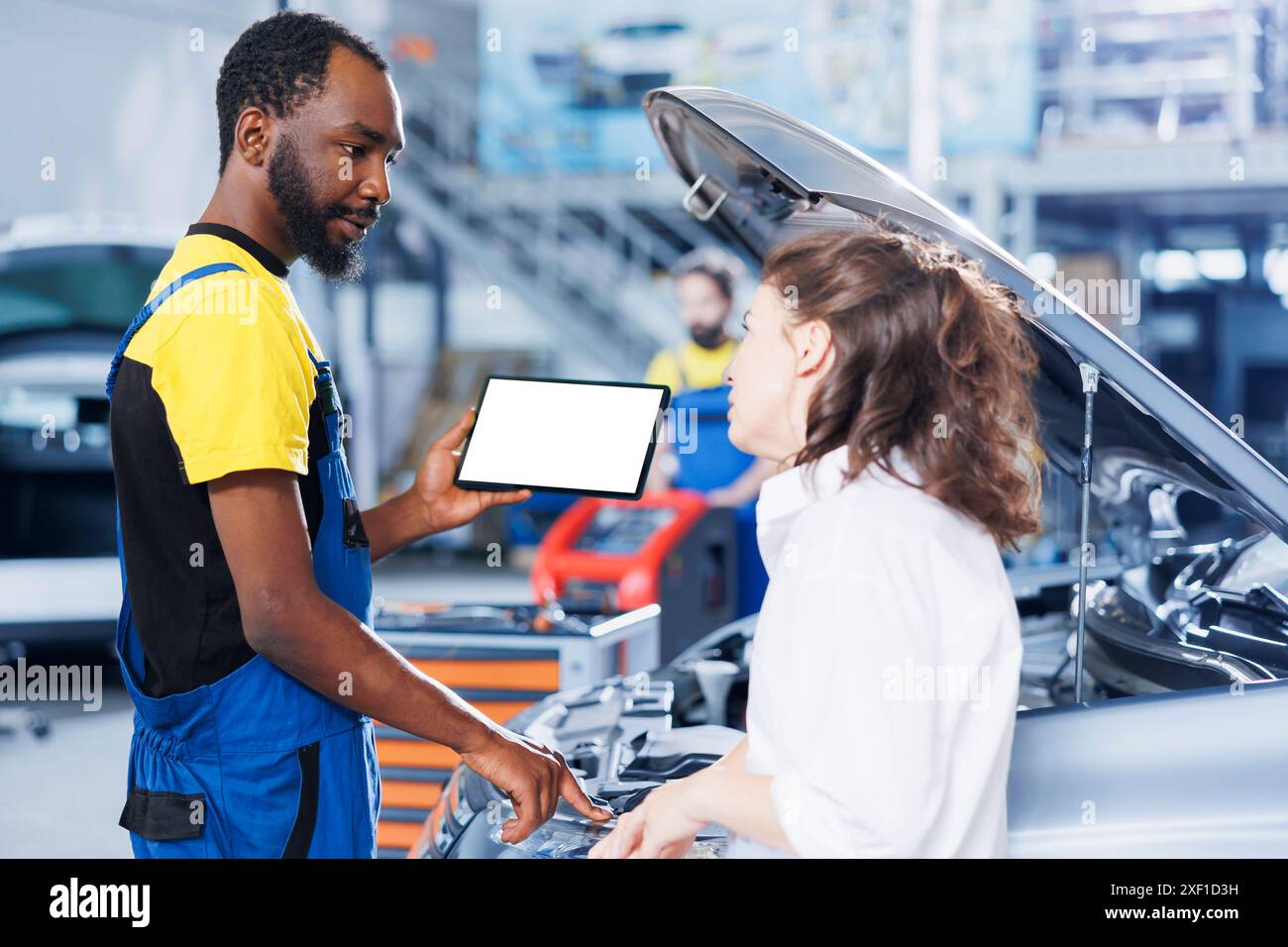 Mechanic in car service uses mockup tablet to order new engine for ...