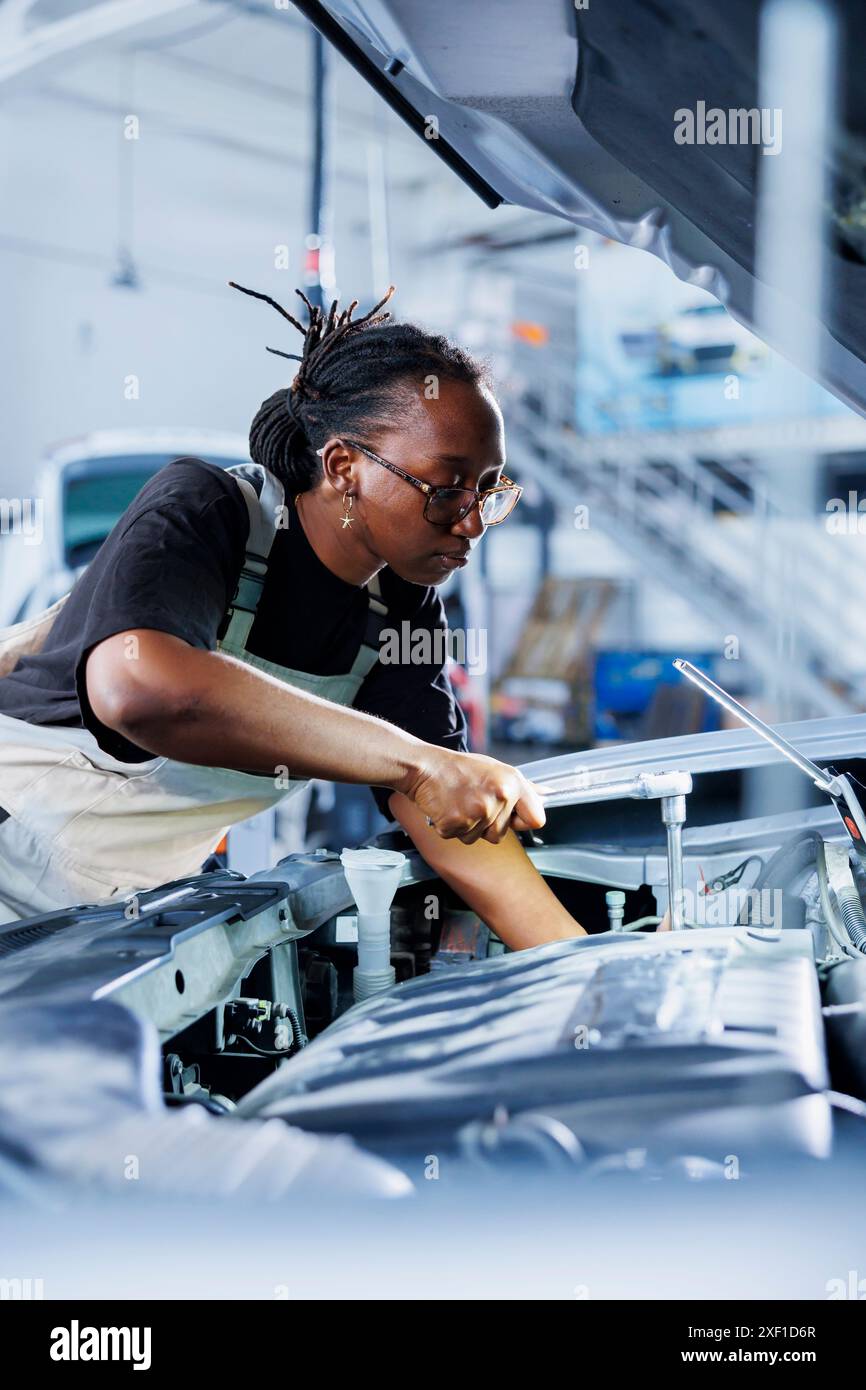 Repair shop technician inspects car engine issues using advanced ...