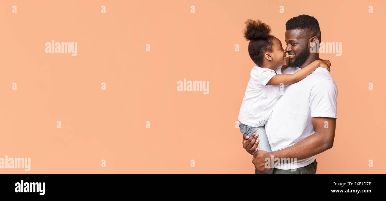 Happy Father Holding Daughter In Front Of Peach Background Stock Photo ...