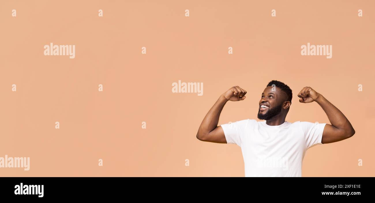 Confident Black Man Flexing Muscles in Studio Setting Stock Photo - Alamy