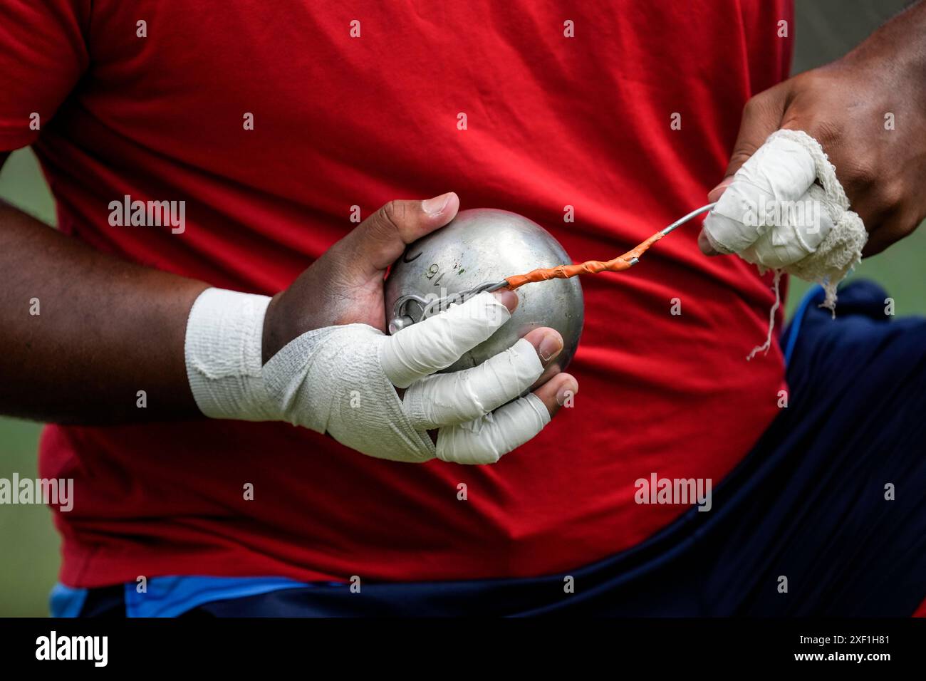 Tarik O'Hagan holds his hammer before competing in the men's hammer ...
