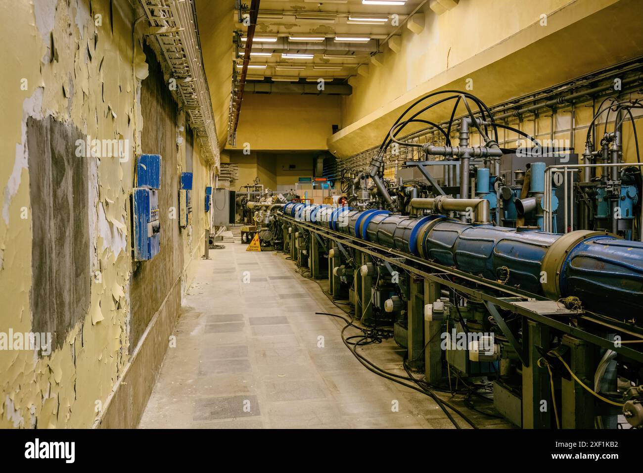 Large metal tube of particle accelerator with connected pipes. Old ...