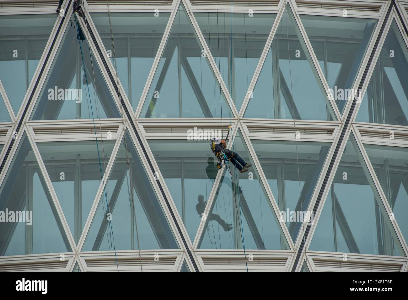Milan Italy 29 June 2024: A rope operator with a harness, lowering ...