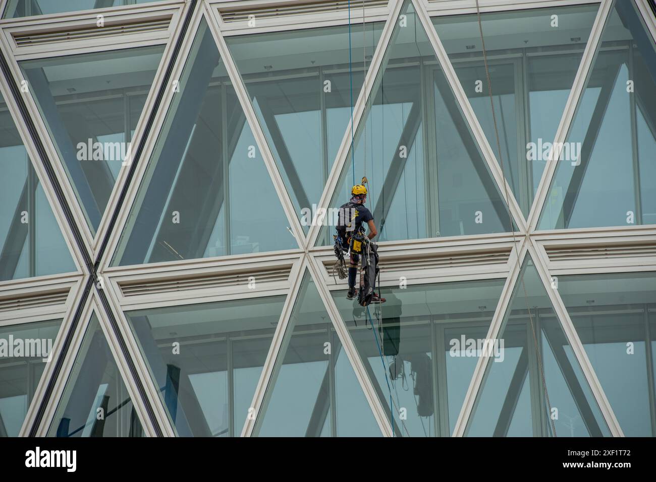 Milan Italy 29 June 2024: A rope operator with a harness, lowering ...