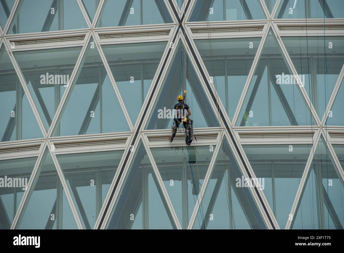 Milan Italy 29 June 2024: A rope operator with a harness, lowering ...