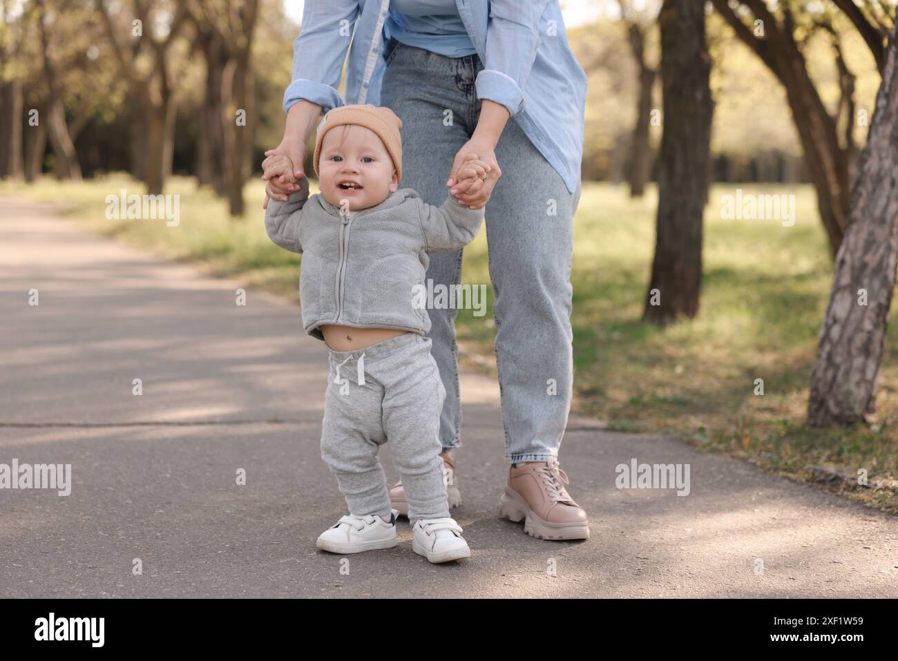 Mother teaching her baby how to walk outdoors, closeup Stock Photo - Alamy