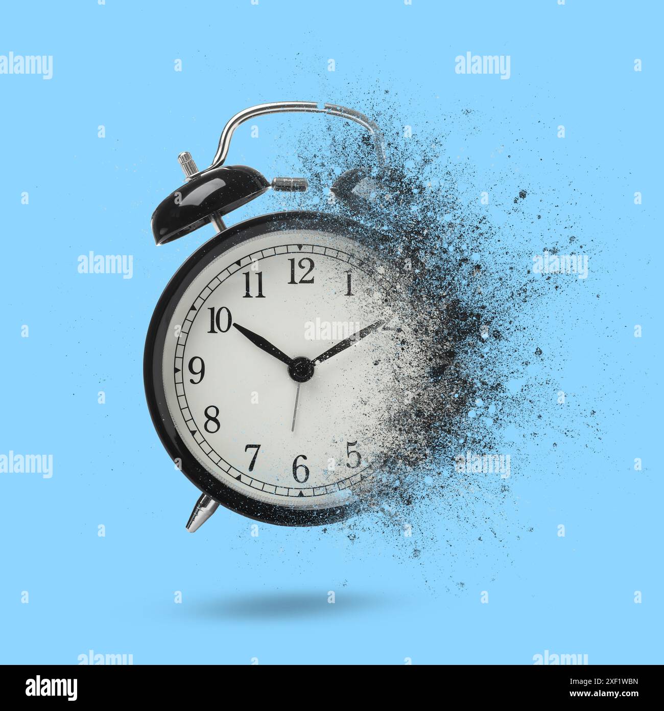 Black alarm clock dissolving on light blue background. Flow of time ...