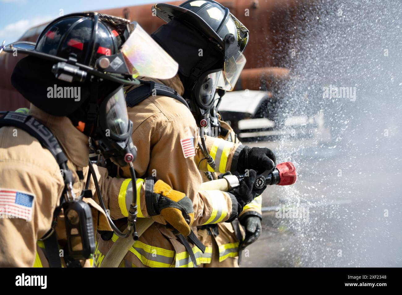 U.S. Airmen with the 52nd Civil Engineer Squadron, use a fire hose ...