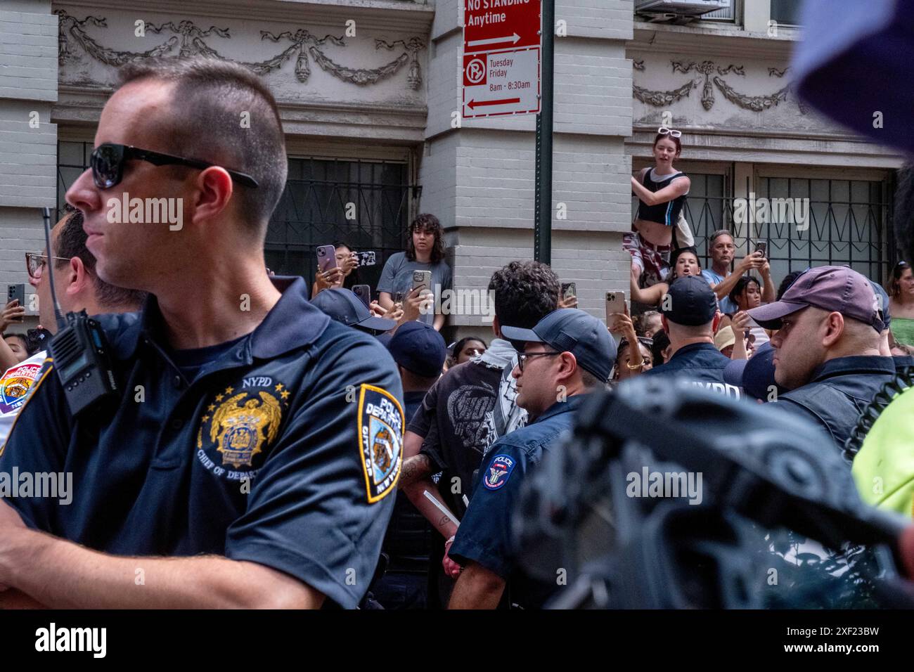 NYPD arrest the protesters as the crowd watches during the ...