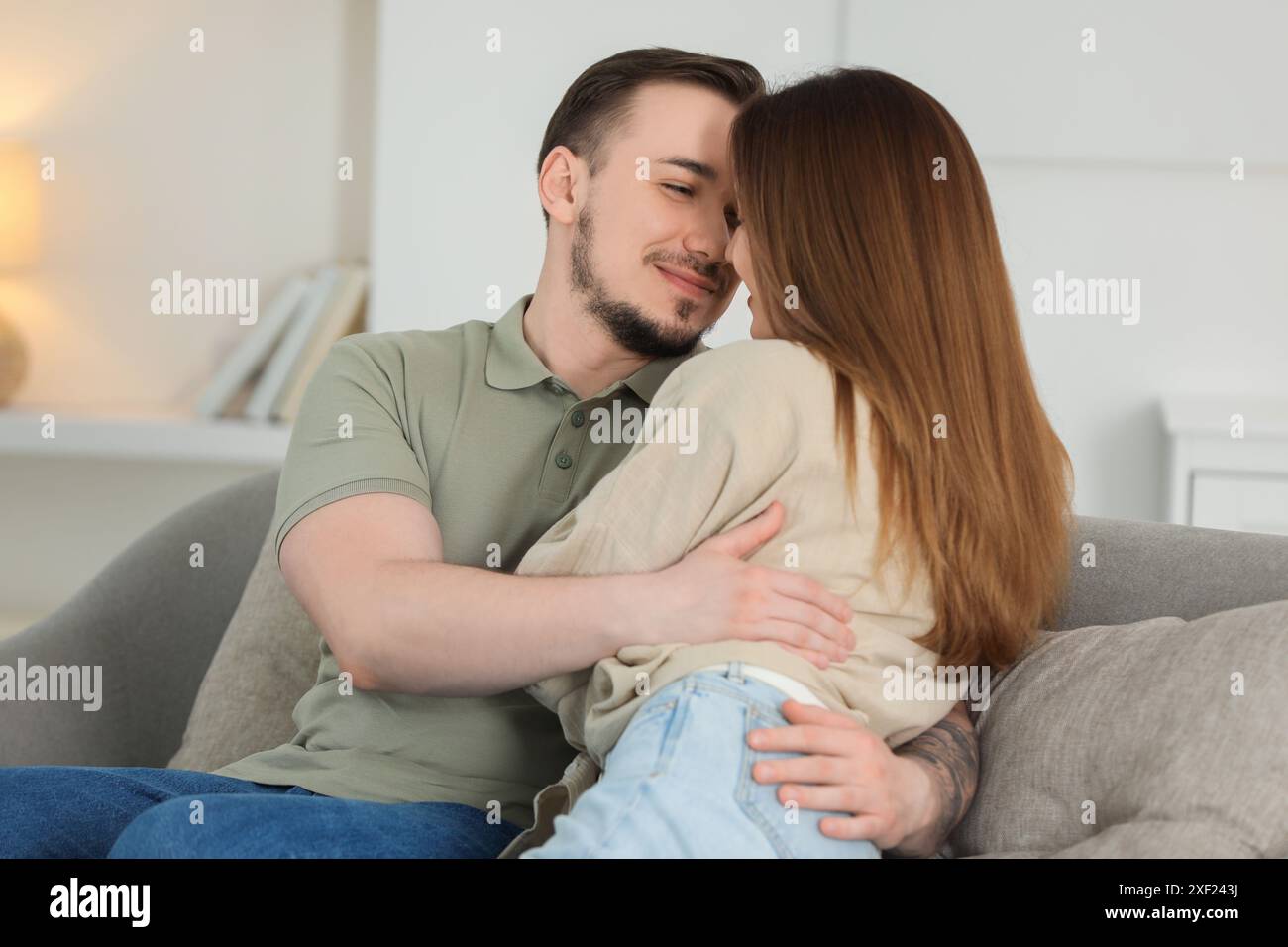Cute couple hugging on sofa at home Stock Photo - Alamy
